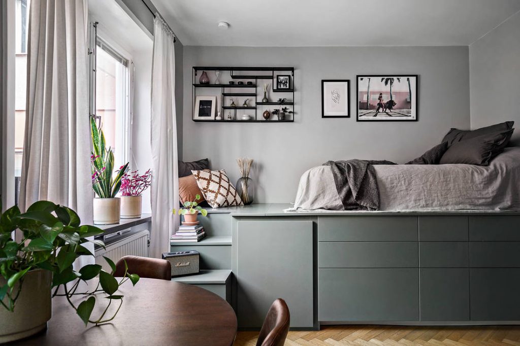 Un lit sur une estrade dans un studio de 23m2 bien organisé