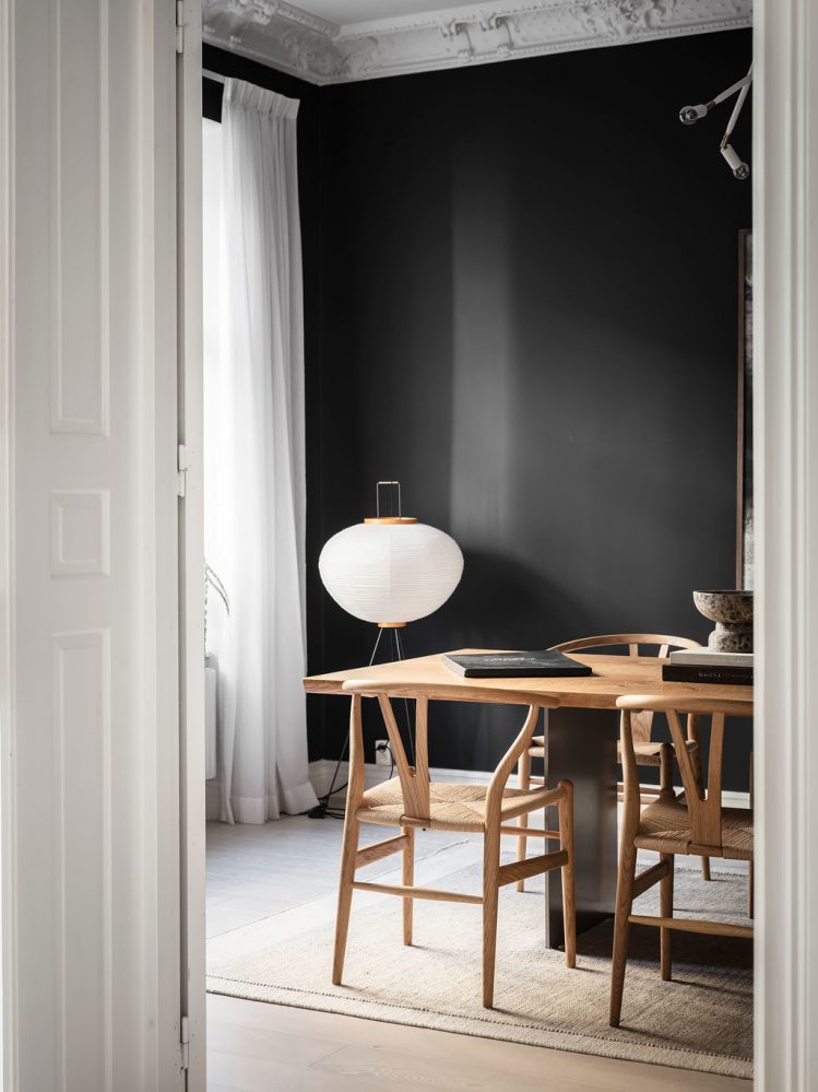 Un mur noir contemporain réveille la décoration de cet appartement