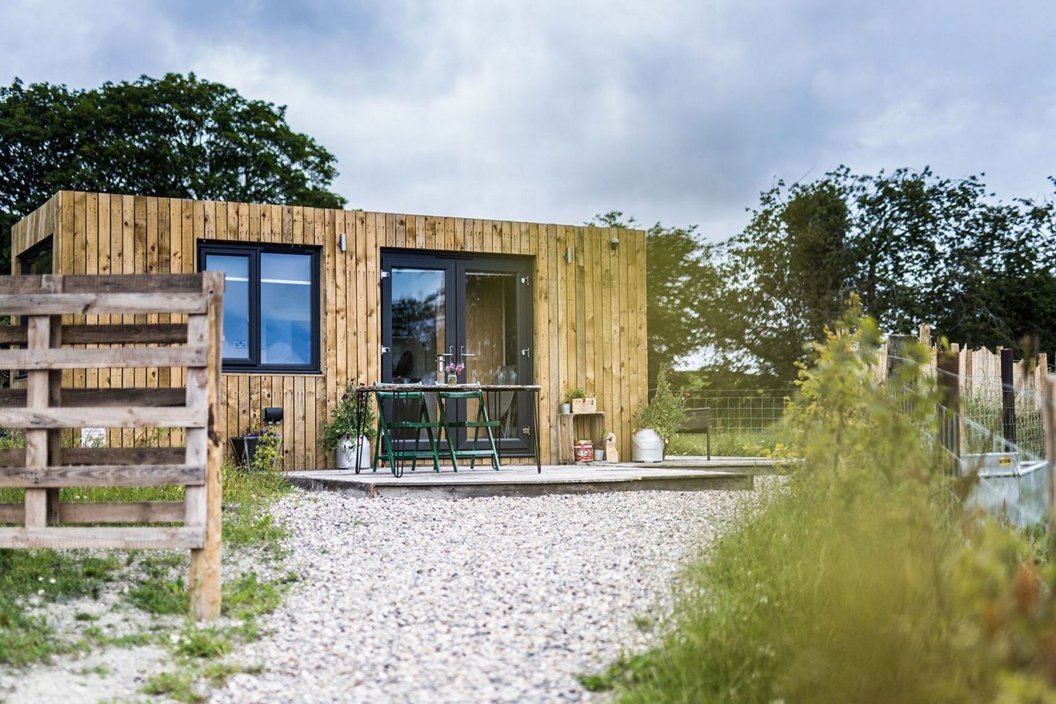 Cette cabane bardée de bois est une mini maison container