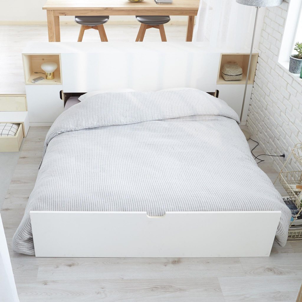 Un lit caché sous une estrade dans le salon d'un studio