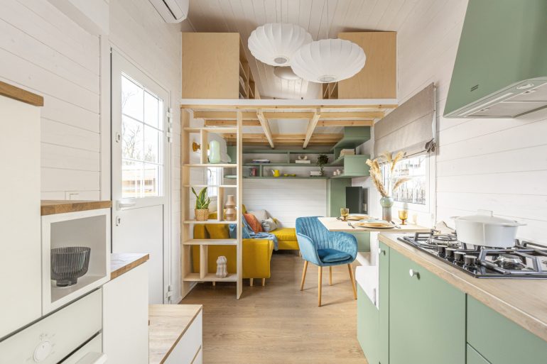Une mini maison container bardée de bois avec des grandes baies vitrées
